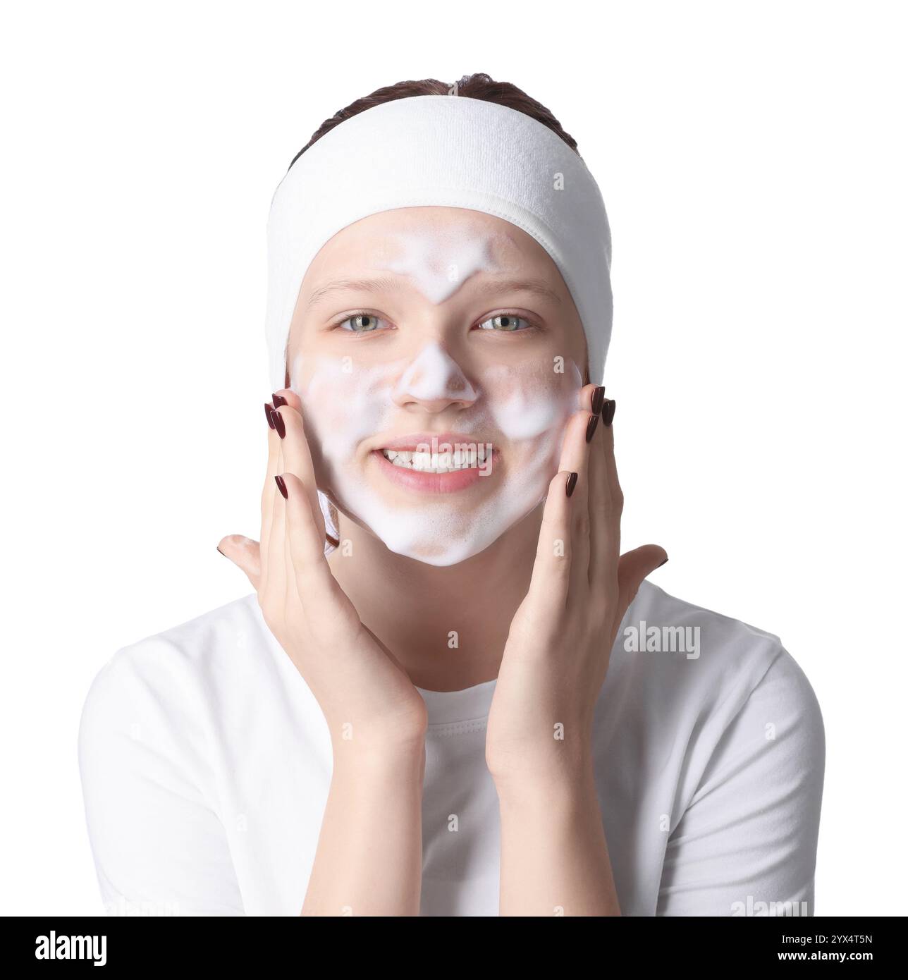 Teenage girl washing her face with cleanser on white background ...