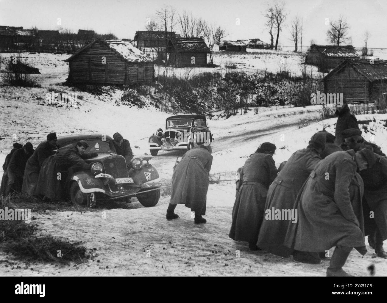 German Wehrmacht vehicles being towed in the snow. The divisional crest ...