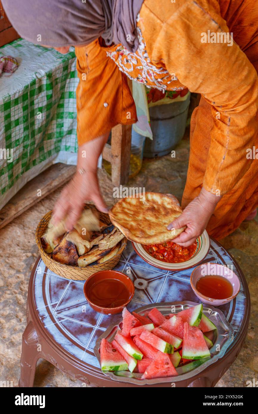 An unknown woman, colorfully dressed, preparing a modest meal Stock ...