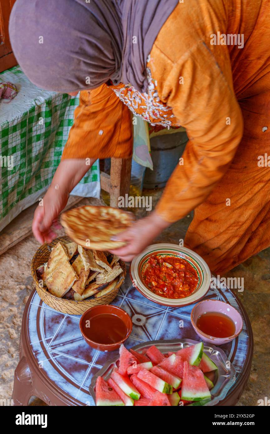 An unknown woman, colorfully dressed, preparing a modest meal Stock ...