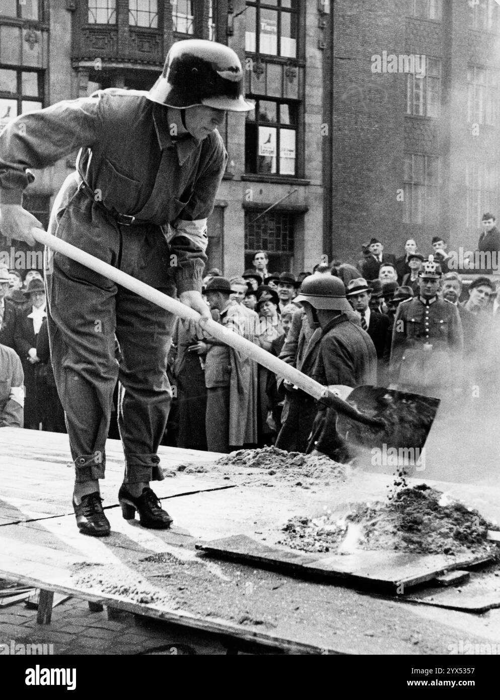 The extinguishing of a fire caused by an incendiary bomb is shown on an ...