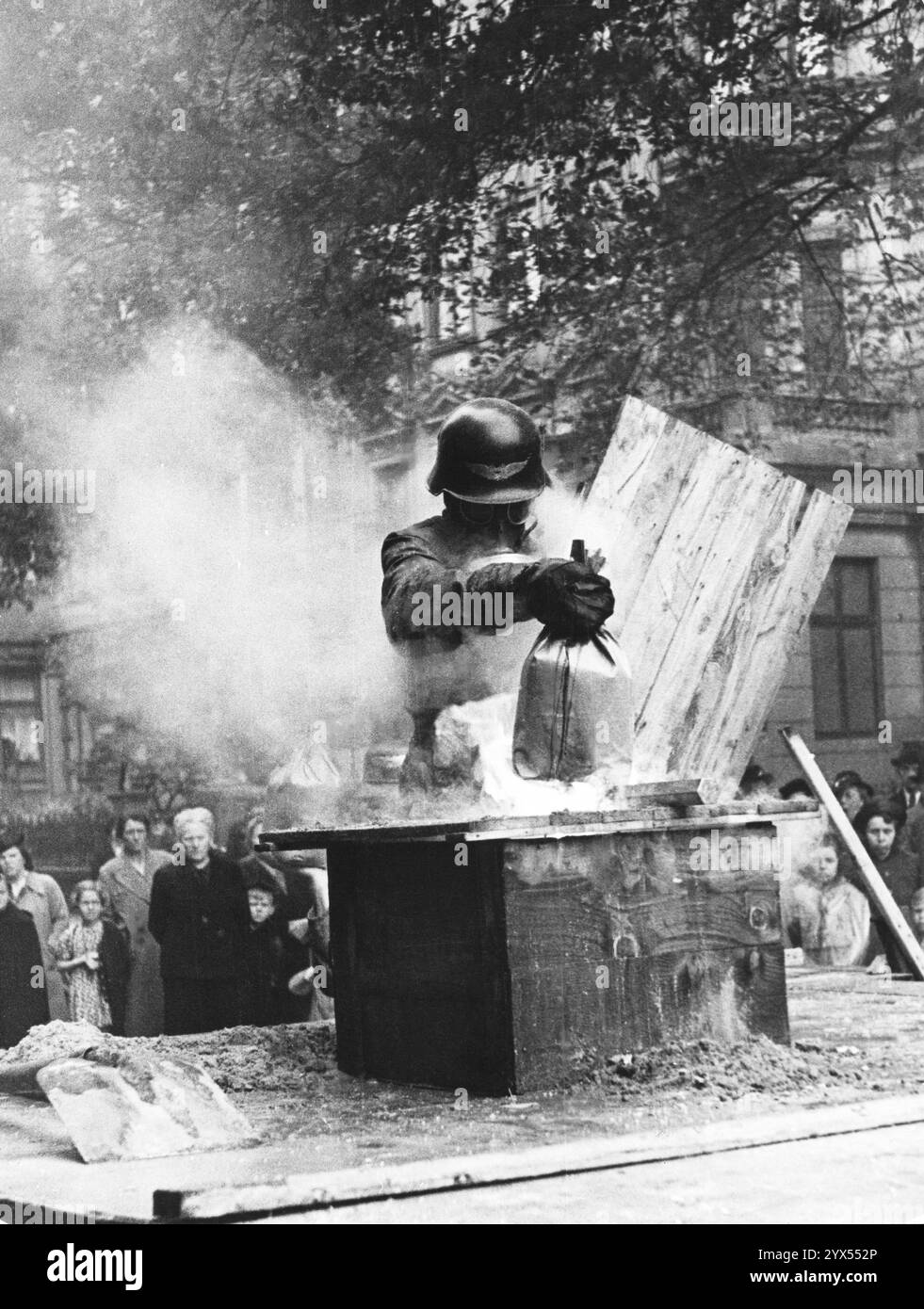 The extinguishing of a fire caused by an incendiary bomb is shown at an ...