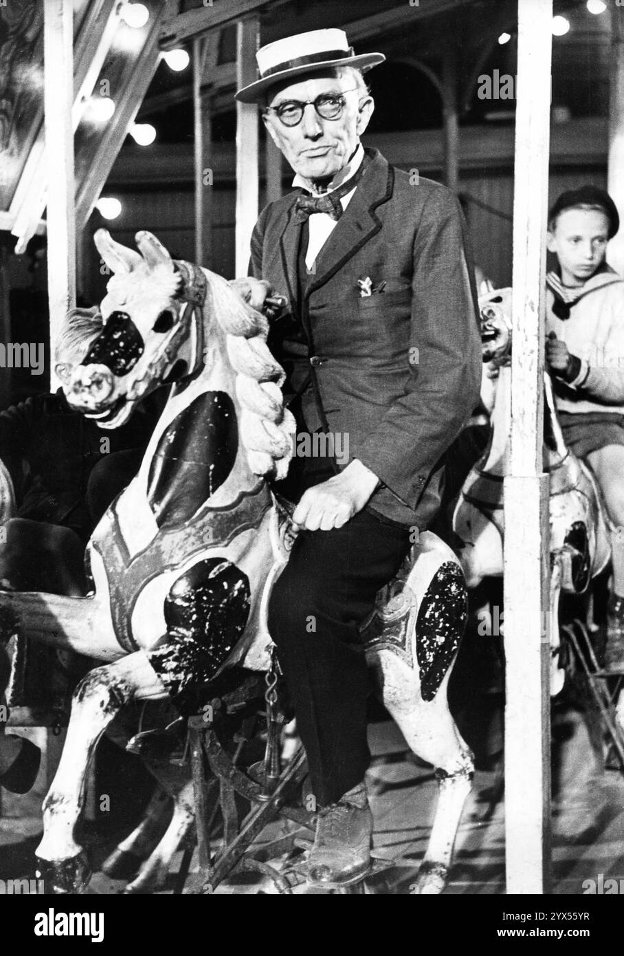 Old man on the wooden horse of a children's carousel in Hamburg ...