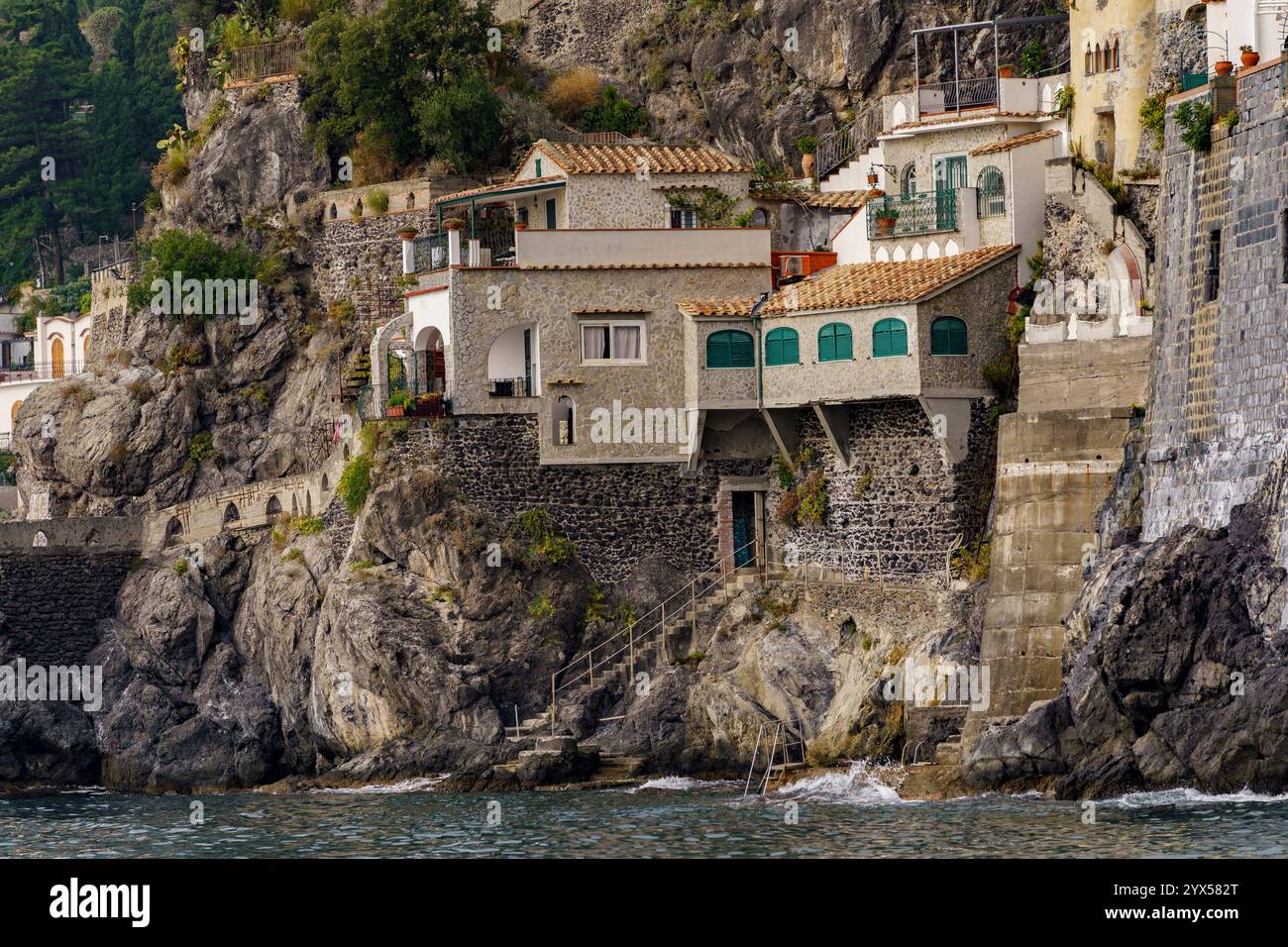 Several small houses on a steep seaside cliff Stock Photo - Alamy
