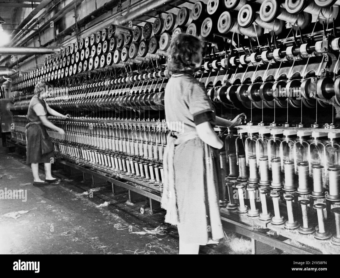 Workers in a cotton spinning mill checking the bobbins. [automated ...