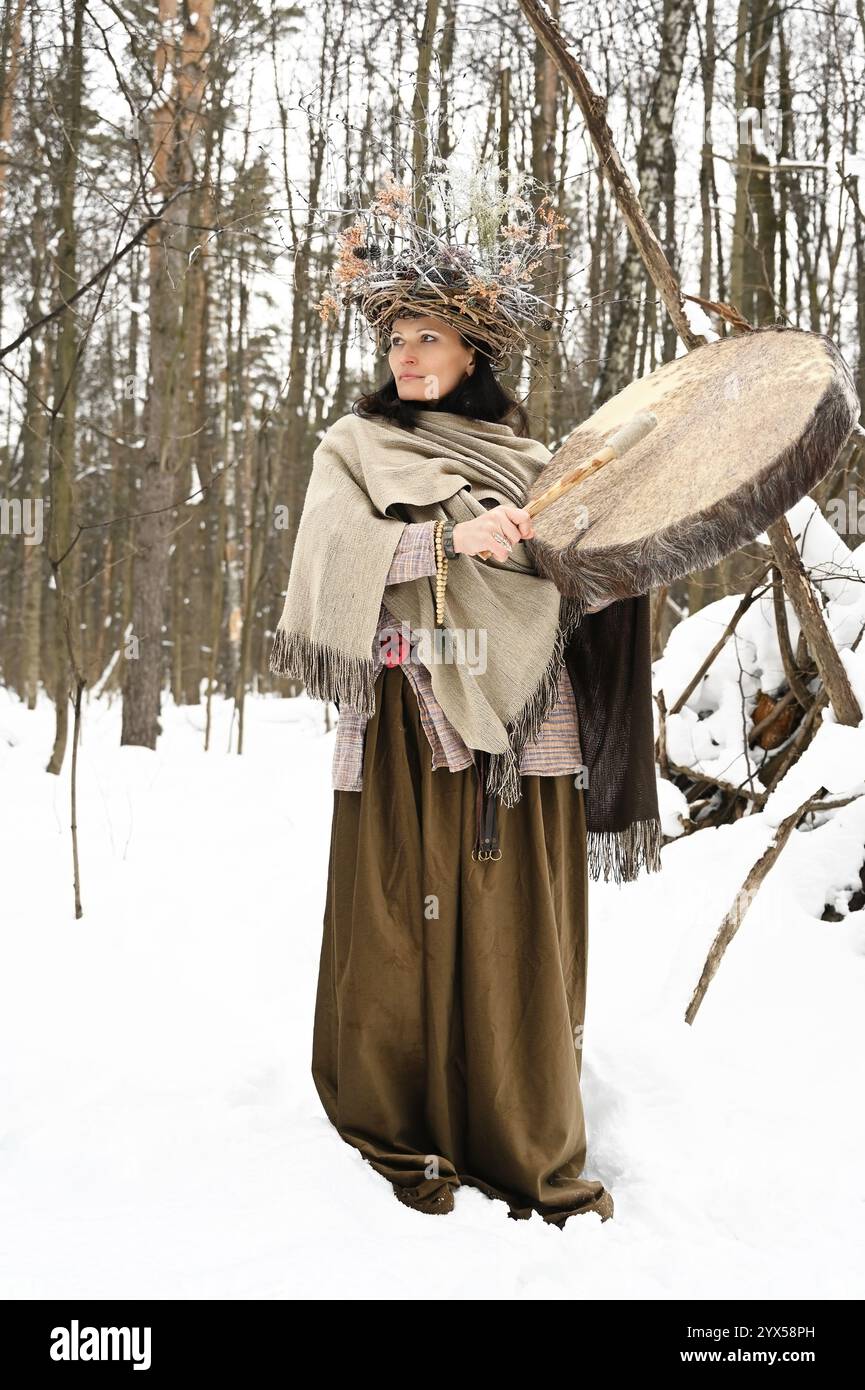 Young adult shaman woman during an outdoor music ceremony in a wild ...
