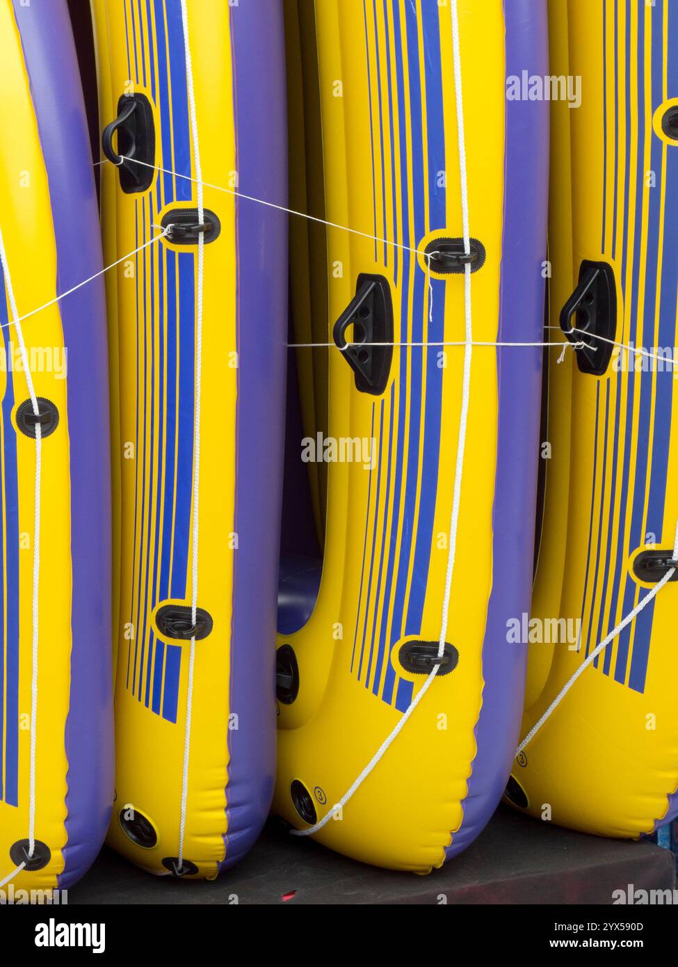 Inflatable dinghy boats stood upright and tied together on display in ...