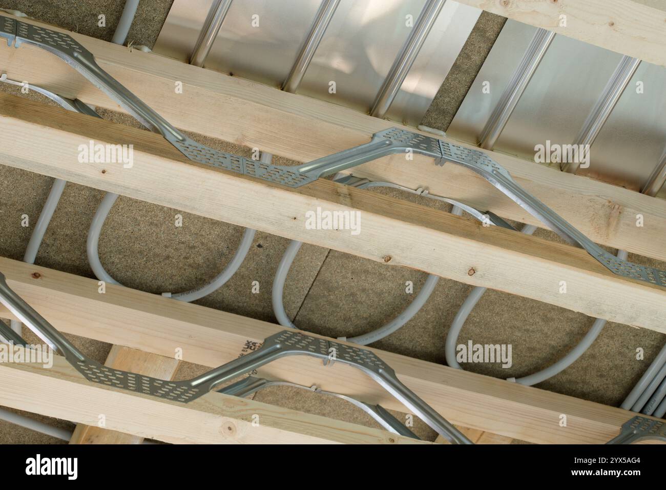 Timber joists of a timber framed building. Underfloor heating pipes ...