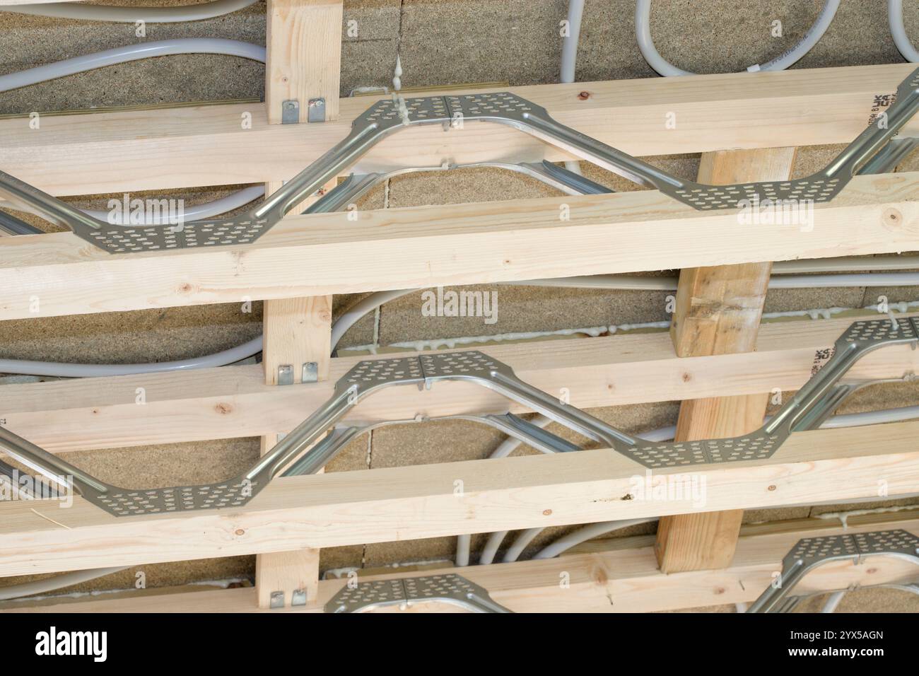 Timber joists of a timber framed building. Underfloor heating pipes ...