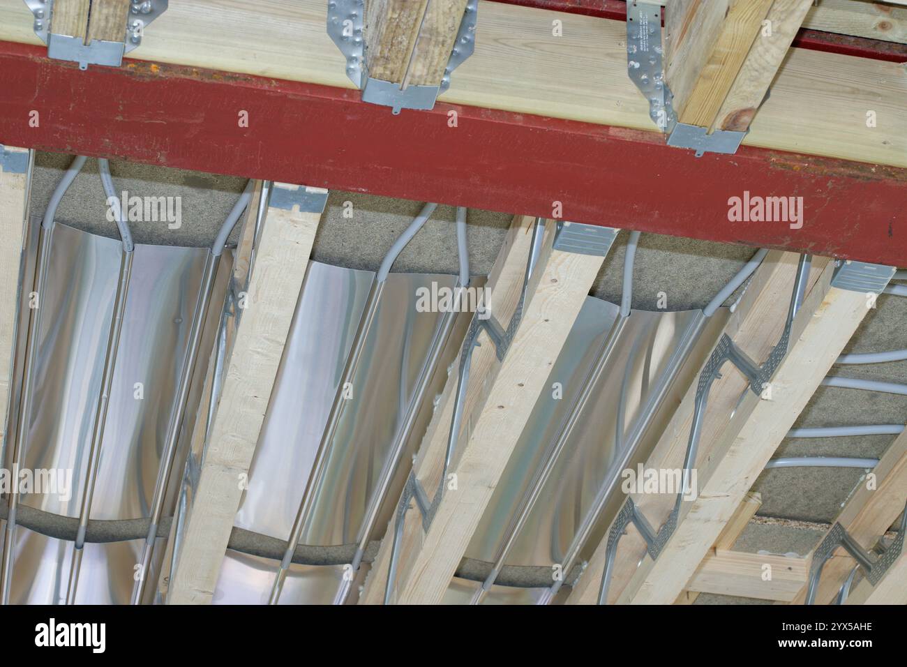 Timber joists of a timber framed building. Underfloor heating pipes ...