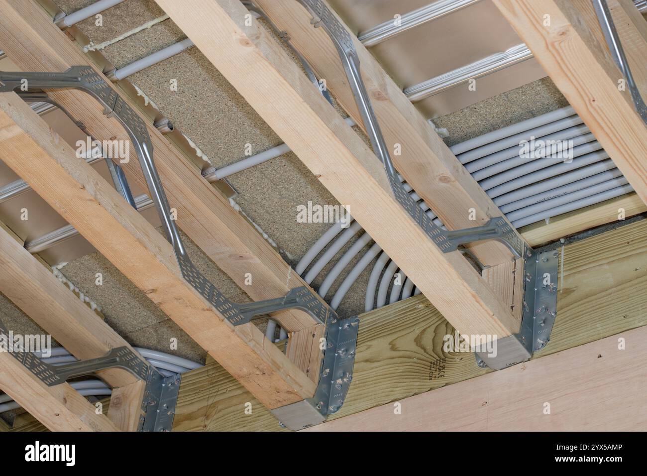 Timber joists of a timber framed building. Underfloor heating pipes ...