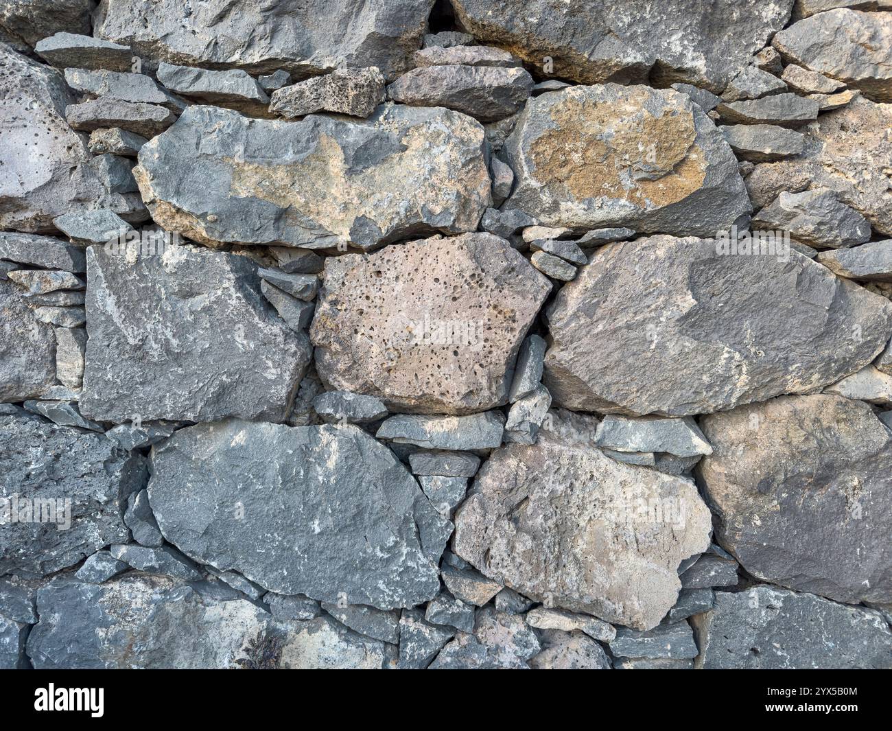 Stone wall folded from volcanic rocks. Close up. Background Stock Photo ...