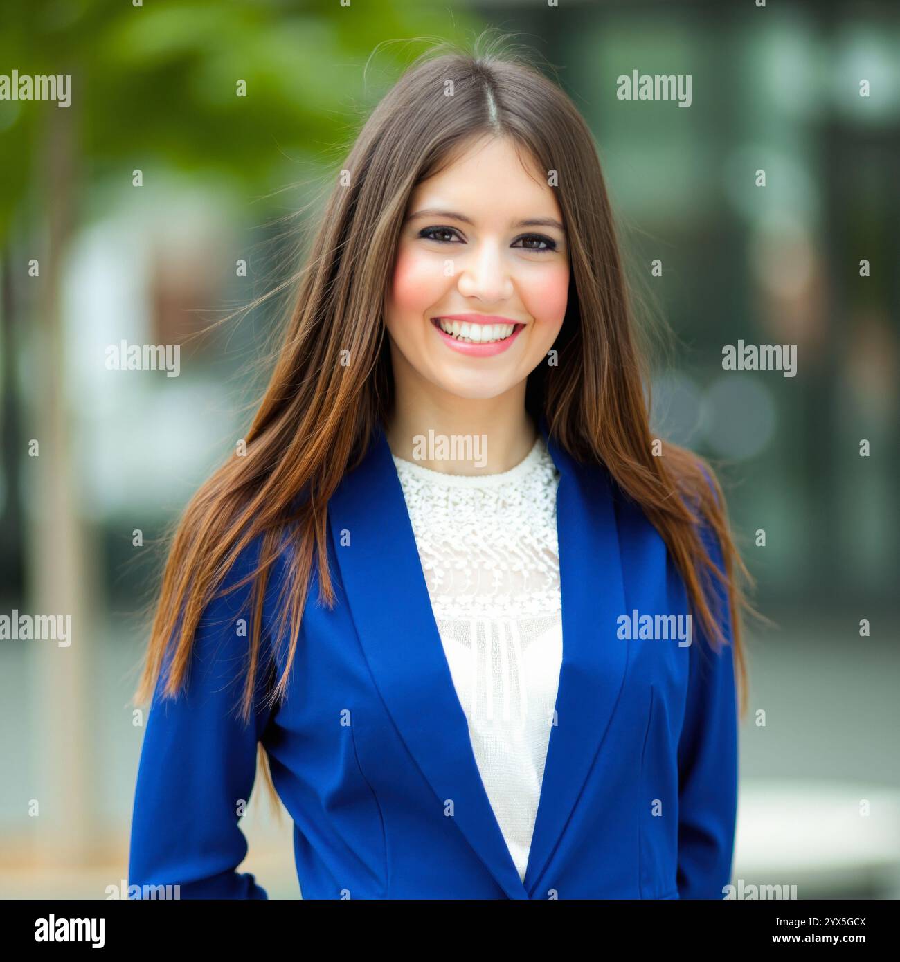 Portrait of a cheerful businesswoman smiling outdoors, wearing a blue ...