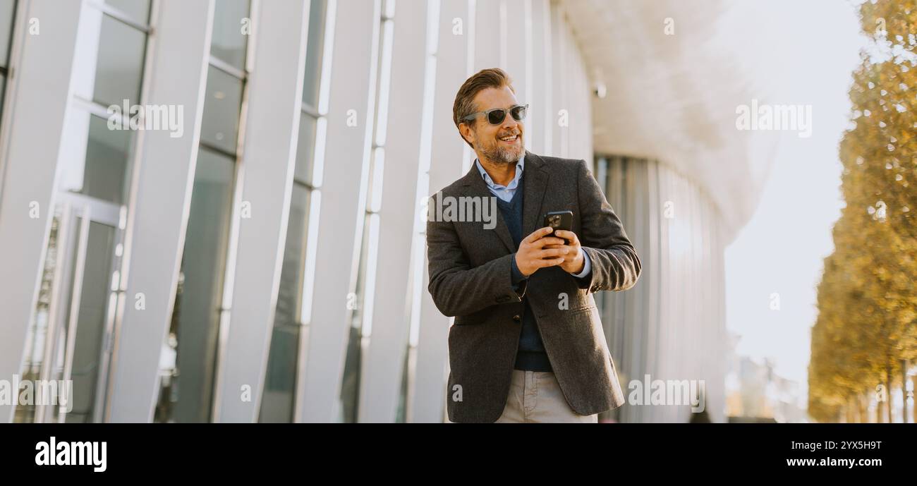 A professional man in stylish attire leisurely walks outside a sleek ...