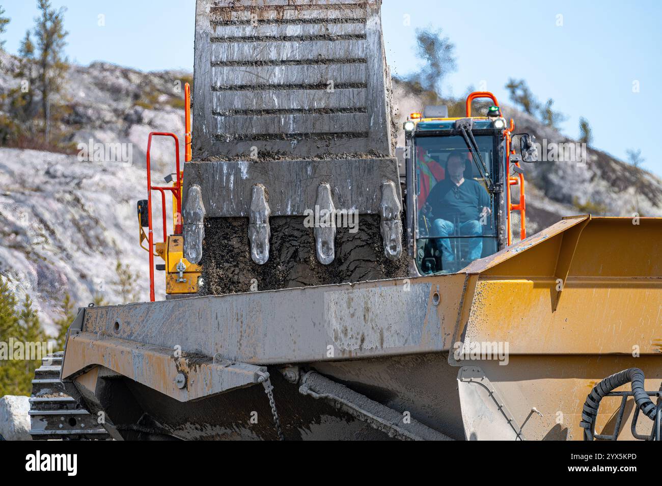 A bucket emptying its load into a dump truck Stock Photo - Alamy