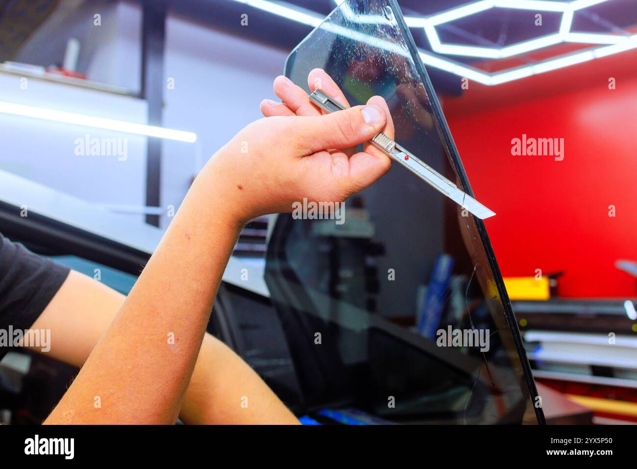 Technician worker is applying window film to vehicle in workshop to ...