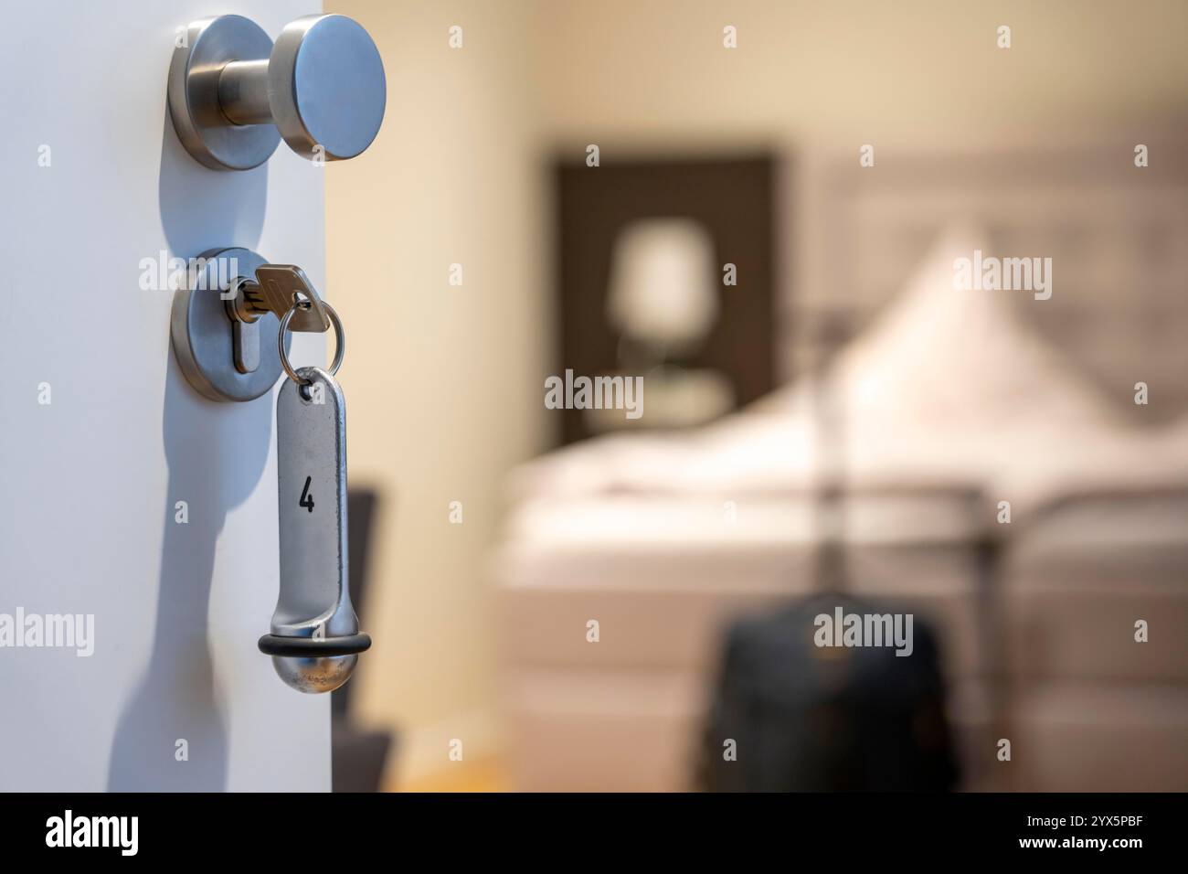 Symbolic image of a hotel, key in the door of a hotel room, analogue ...