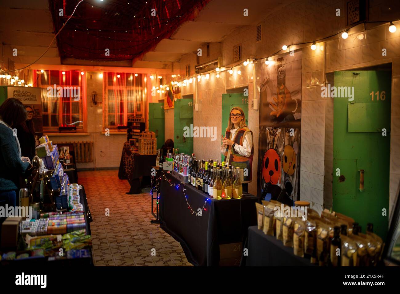A saleswoman stands in front of the green prison cell doors during the ...