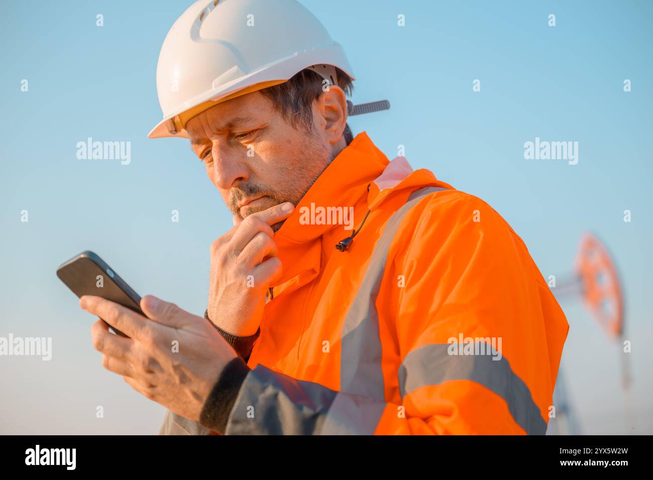 Drilling rig engineer using mobile phone while supervising the process ...