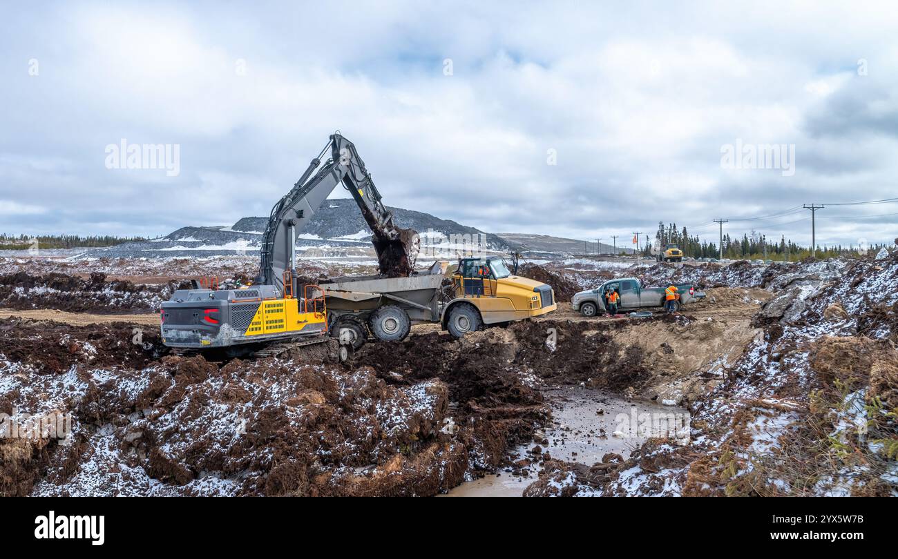 Peat excavation with an excavator and dump trucks, in winter Stock ...