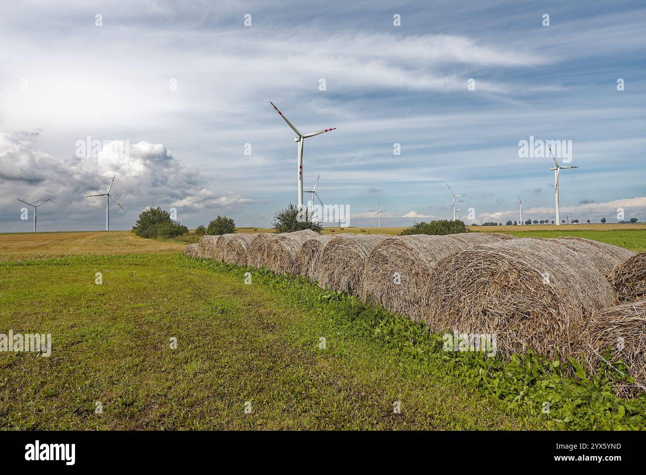 Straw bales on farmland with wind turbine Stock Photo - Alamy