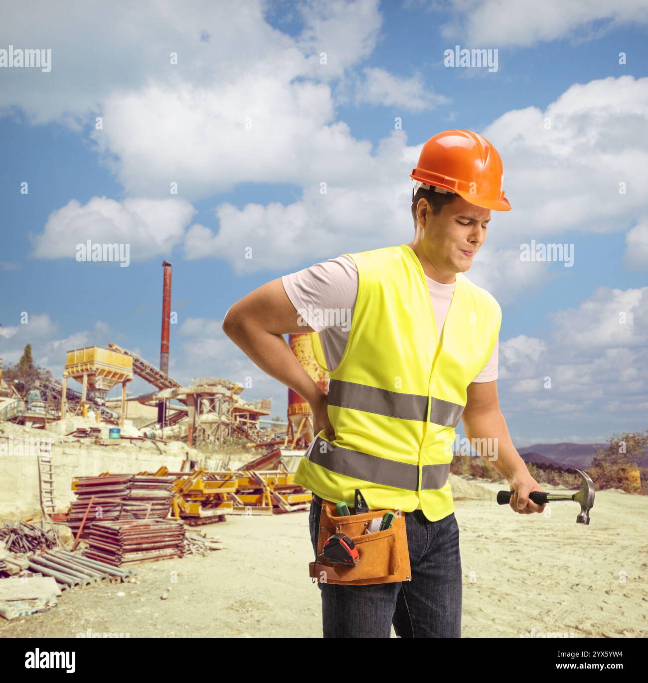 Construction worker holding his back in pain at a construction site ...