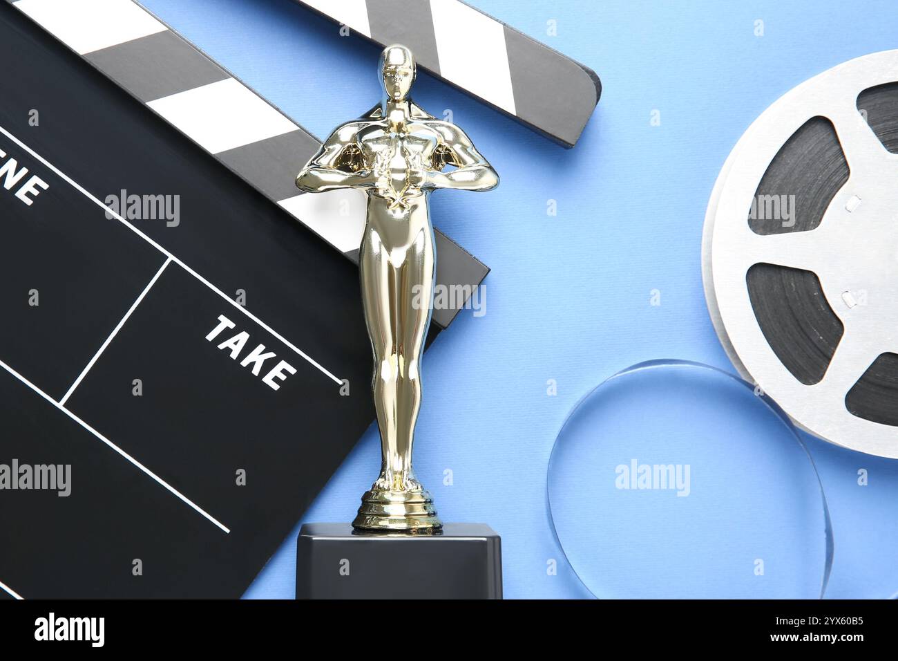 Golden trophy in shape of human figure, movie clapper and film reel on ...