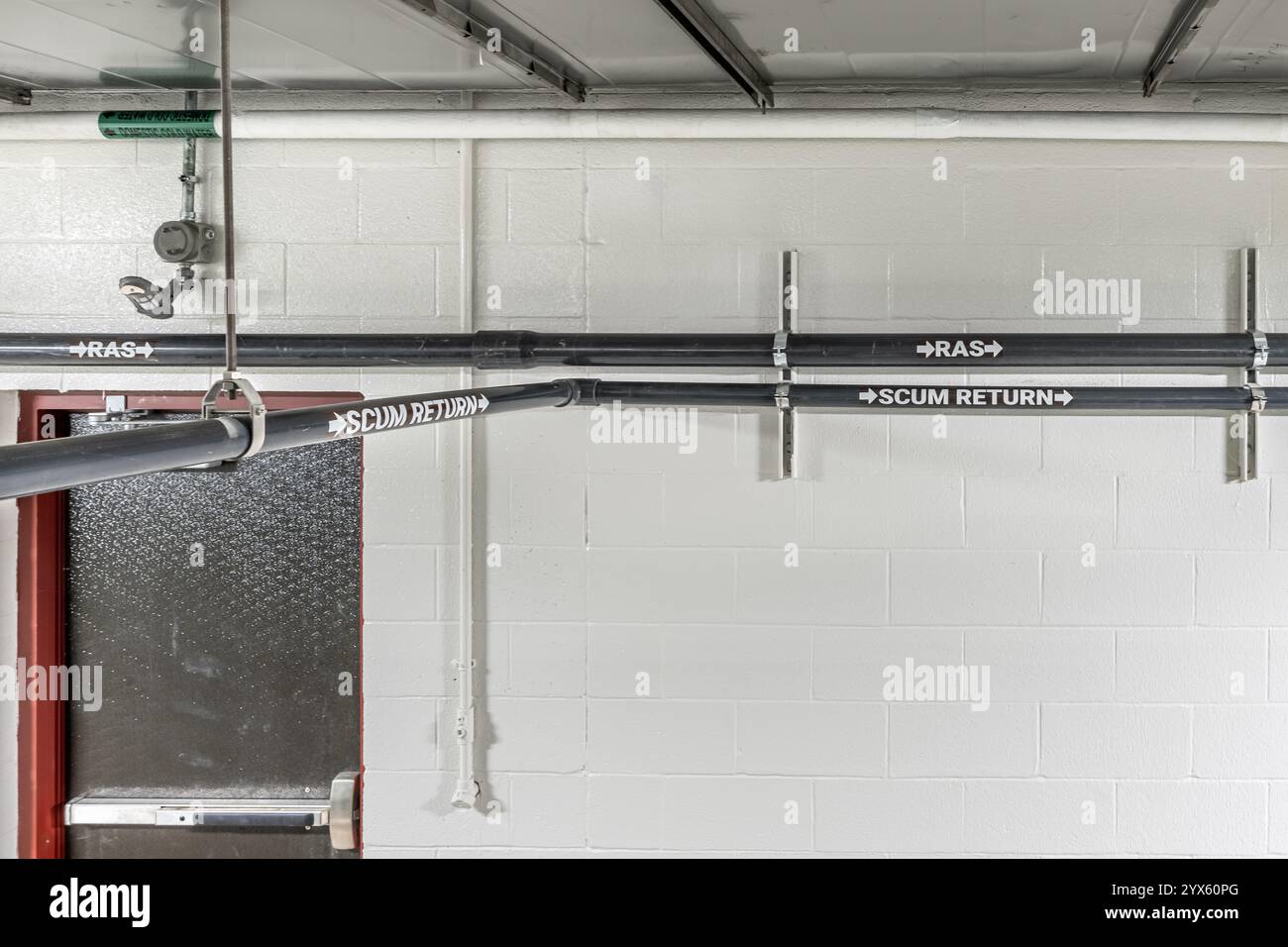 Plastic pipes inside a new small waste water treatment plant labeled ...