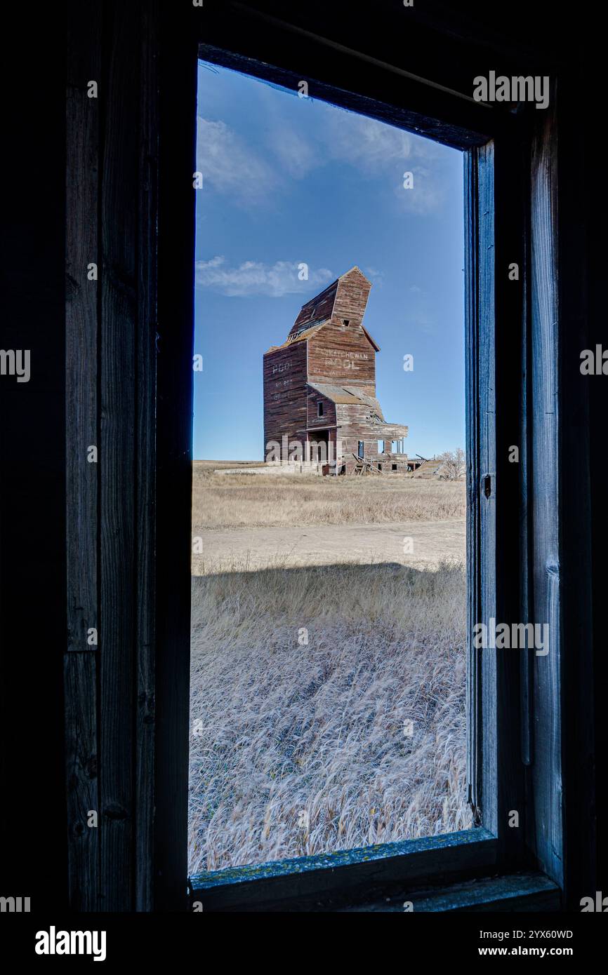 A window with a view of a large, old building. The building is in a ...