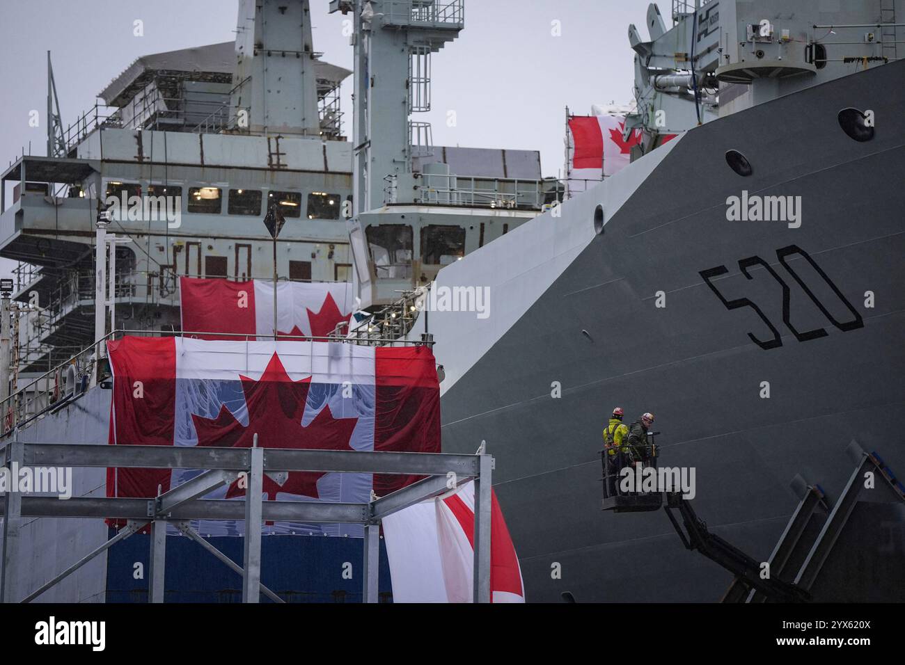 Workers are seen on a lift beside the new Royal Canadian Navy Joint ...