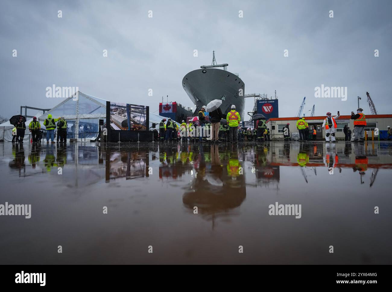 North Vancouver, Canada. 13th Dec, 2024. Workers take photographs and ...