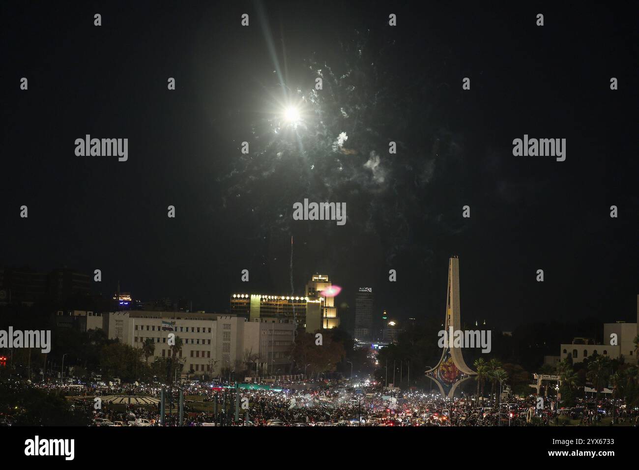 Fireworks light up the night sky as people gather in Umayyad Square to ...