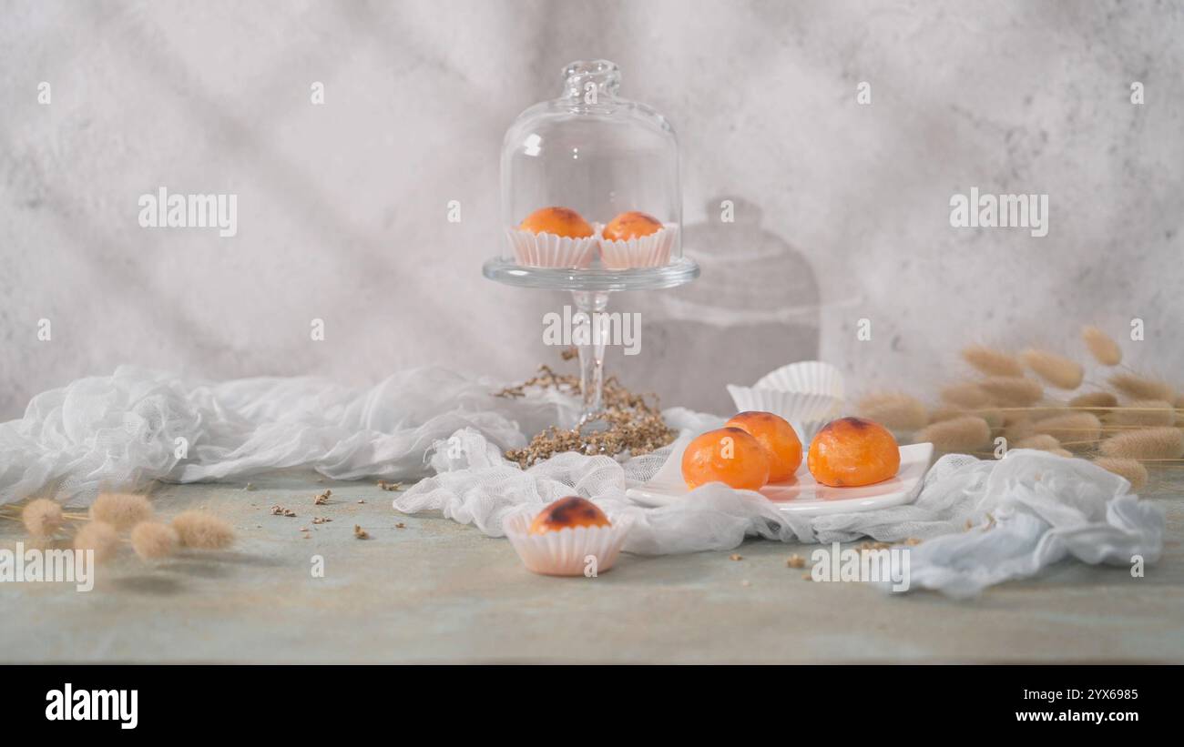 Elegant dessert display featuring golden-brown pastries under a glass ...