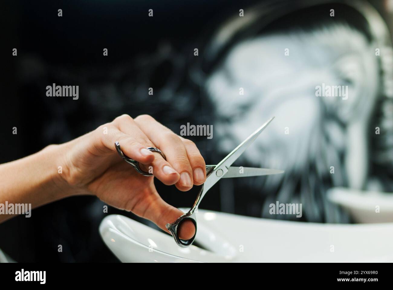 Male hand holding open scissors for cutting hair on dark background ...