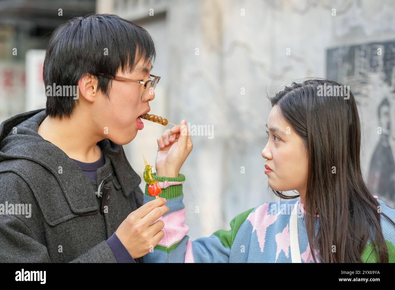 Young Chinese couple in their 20s eating Beijing's famous sugar-coated ...