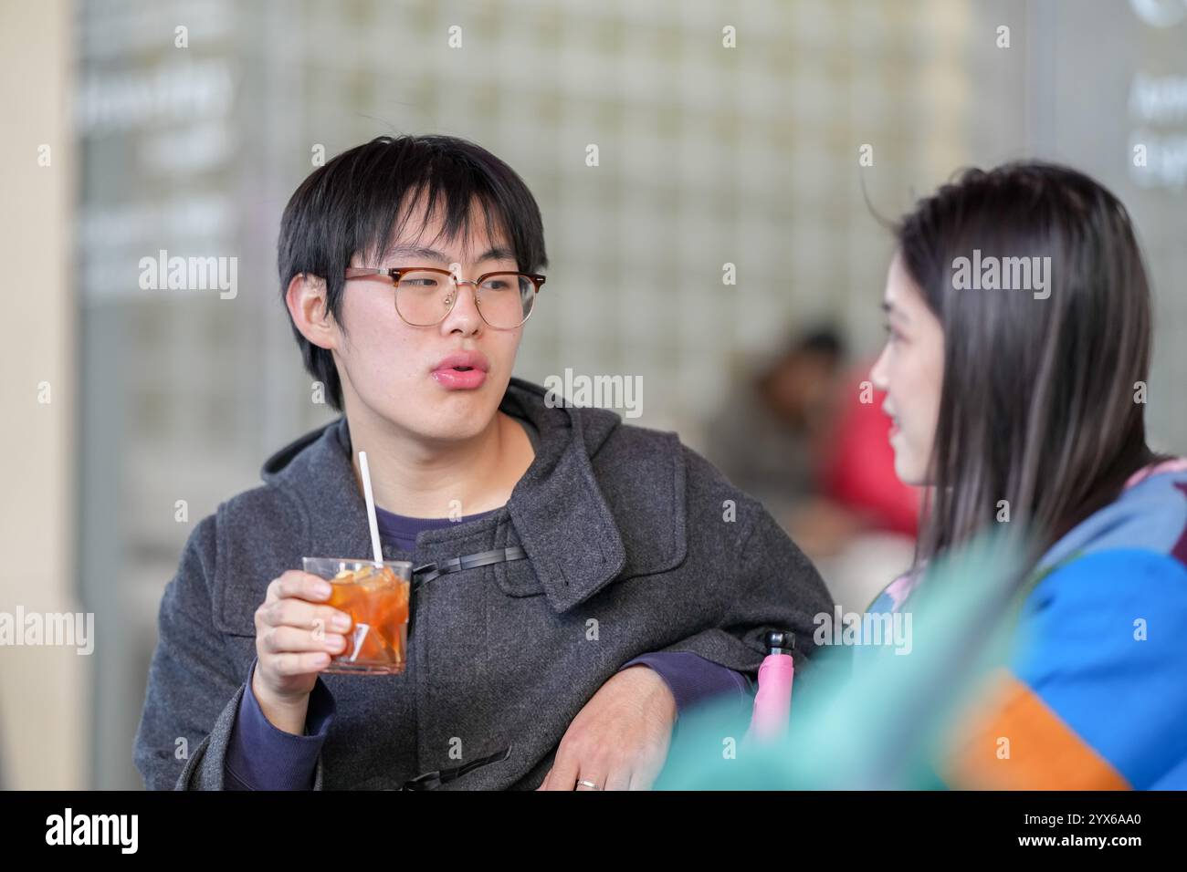 A young Chinese couple in their 20s drinking coffee or tea on the ...