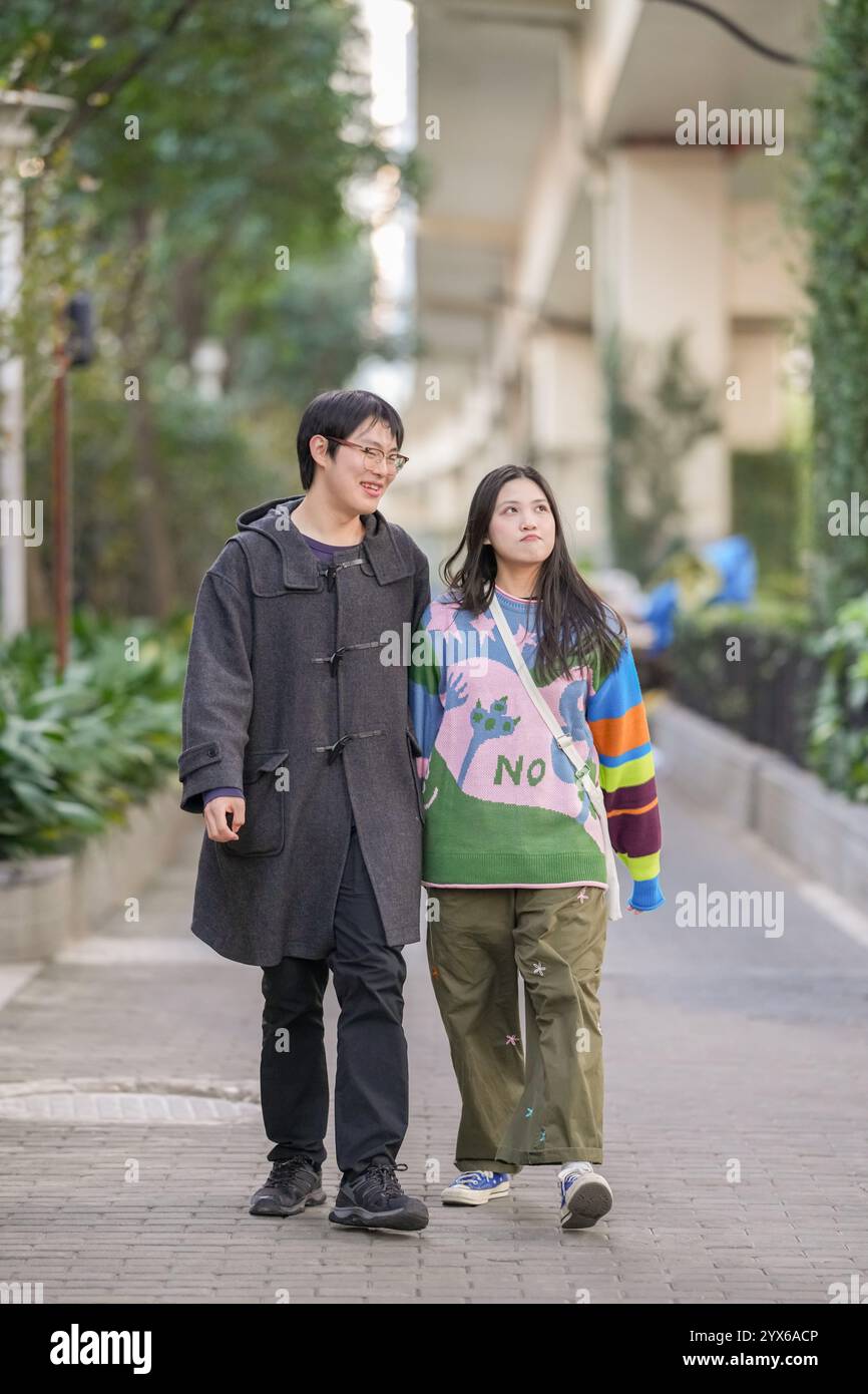 Young Chinese couple in their 20s standing on sidewalk in Hongkou ...