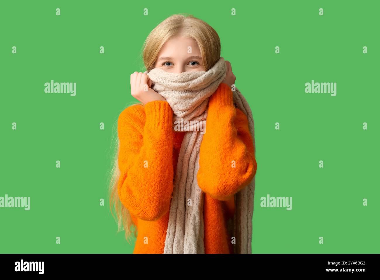 Frozen young woman in warm winter clothes on green background Stock ...