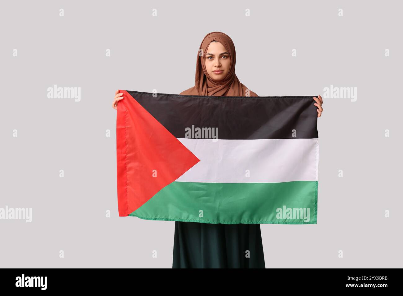 Young Muslim woman with Palestine flag on grey background. Sorrow ...
