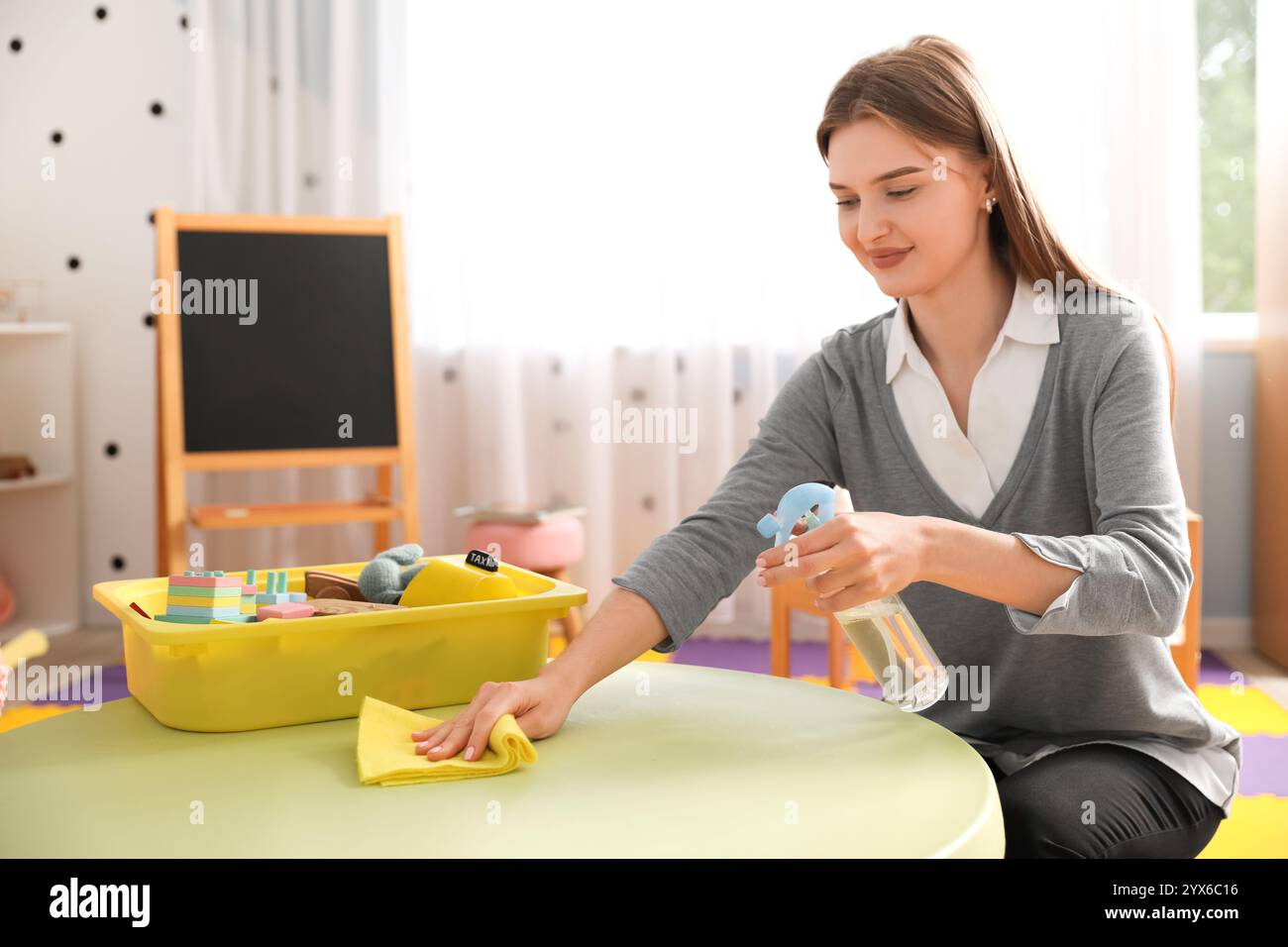 Female nursery teacher cleaning table in kindergarten Stock Photo - Alamy
