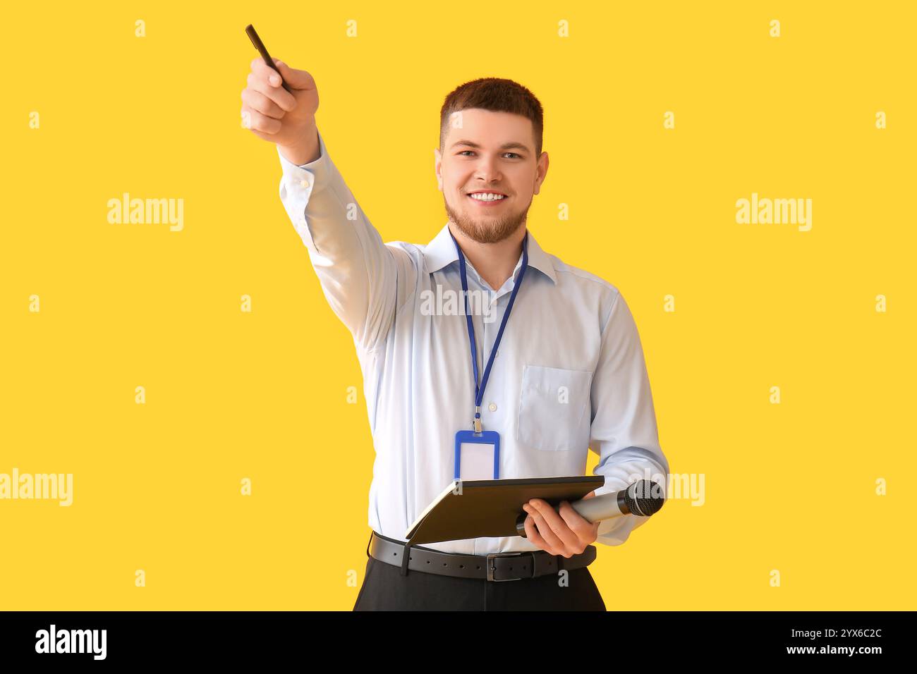 Male reporter with microphone and clipboard asking question on yellow ...