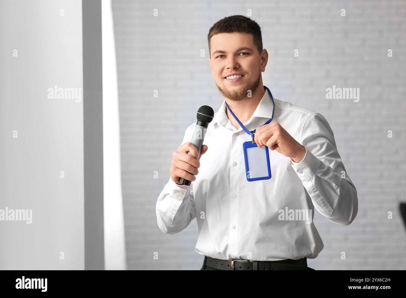 Male reporter with microphone and blank name tag in office Stock Photo ...