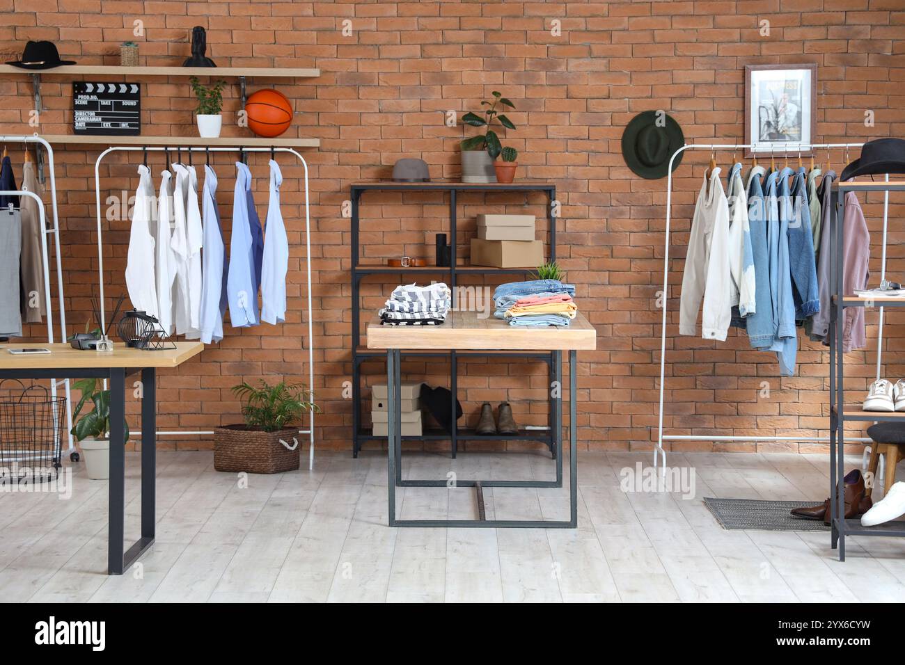 Interior of men's clothing store with shelf unit, tables and racks ...