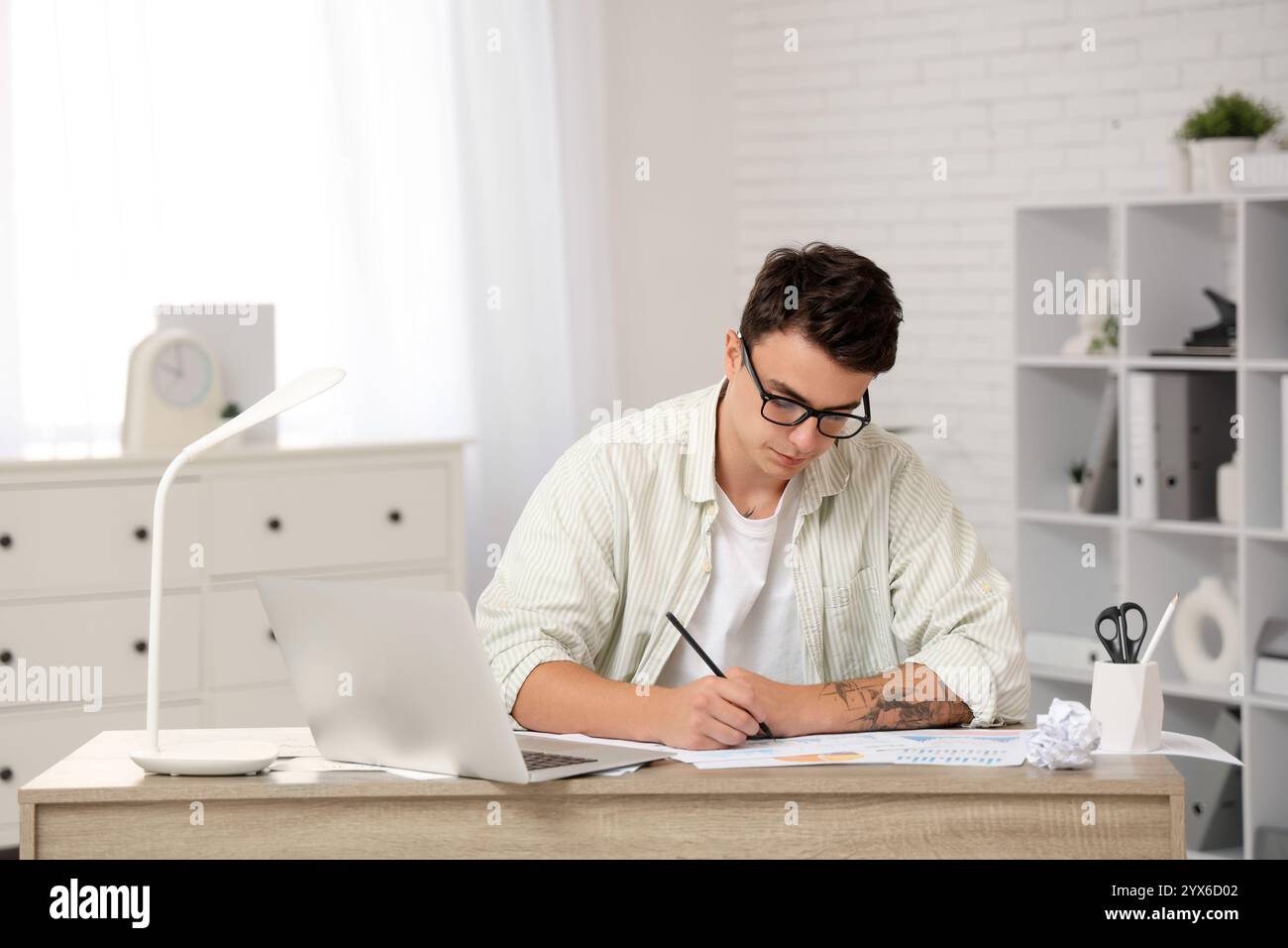 Male economist working with diagrams at table in office Stock Photo - Alamy