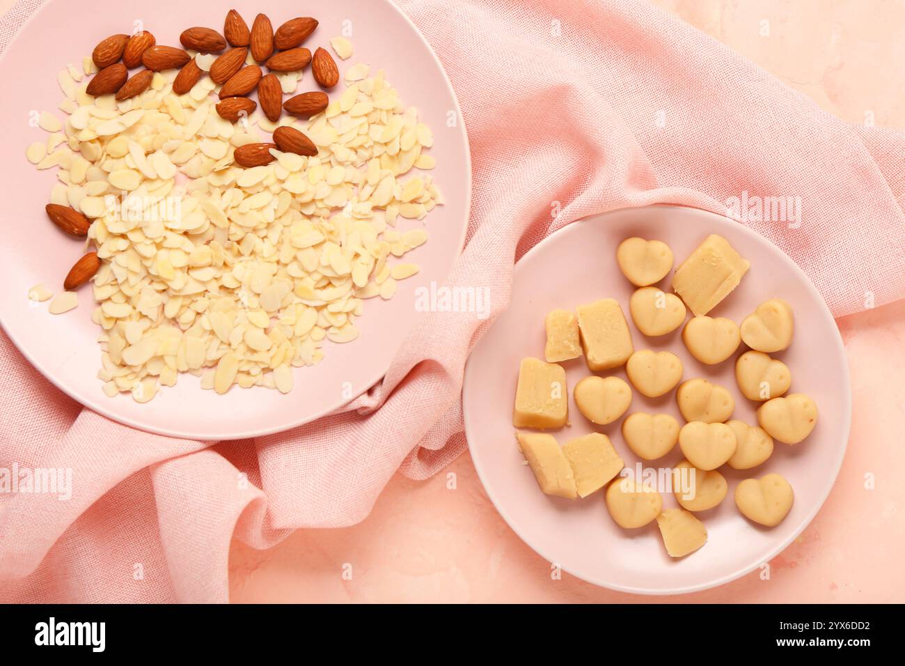 Plates with tasty marzipan candies, almond flakes and nuts on color ...