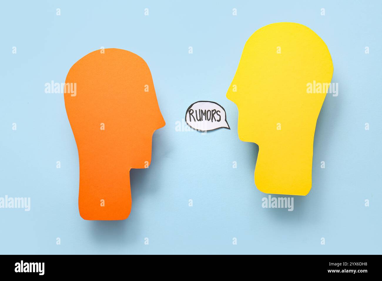 Paper human heads and speech bubble with word RUMORS on blue background ...