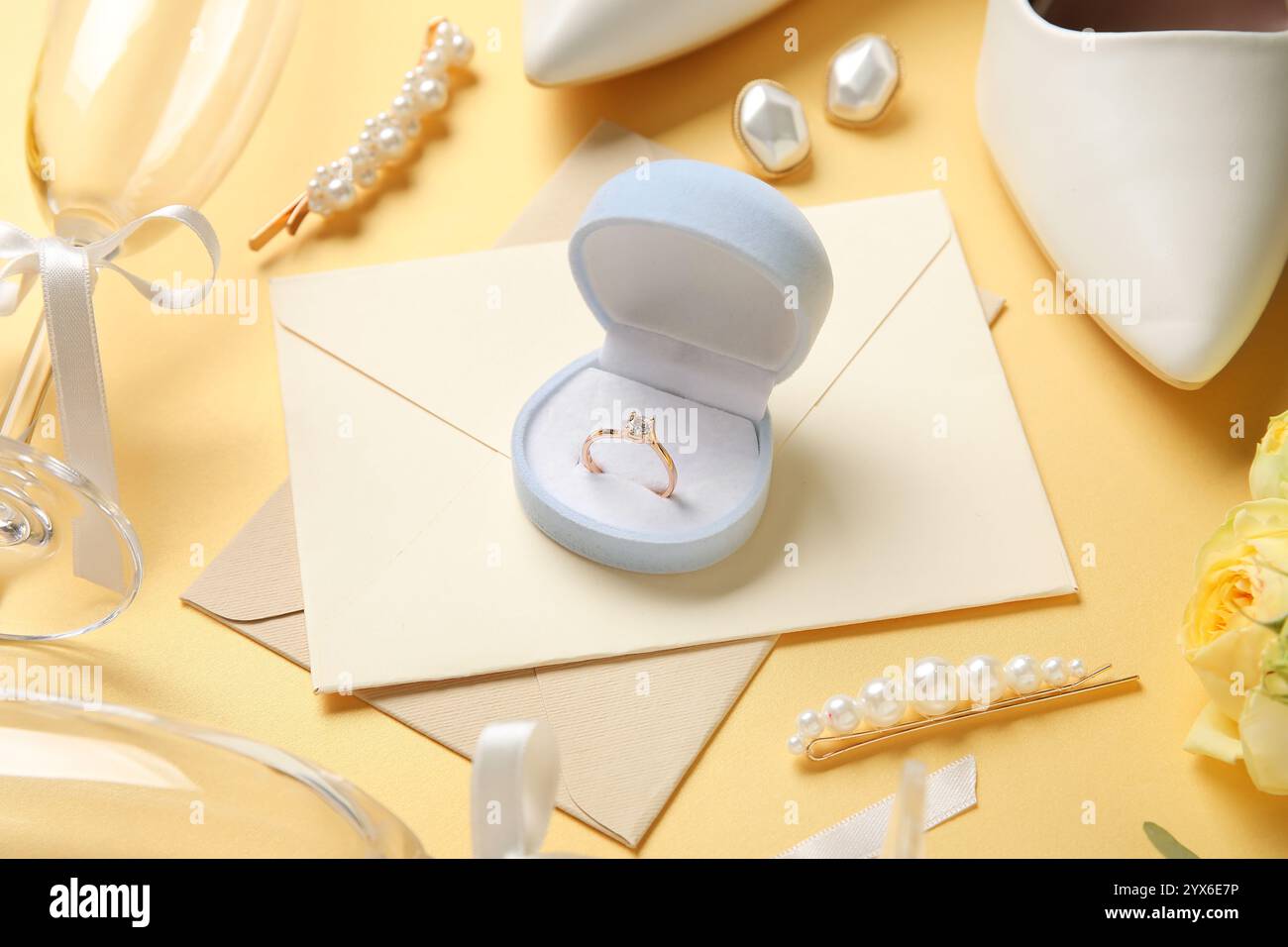 Engagement ring with envelopes and bridal accessories on yellow ...