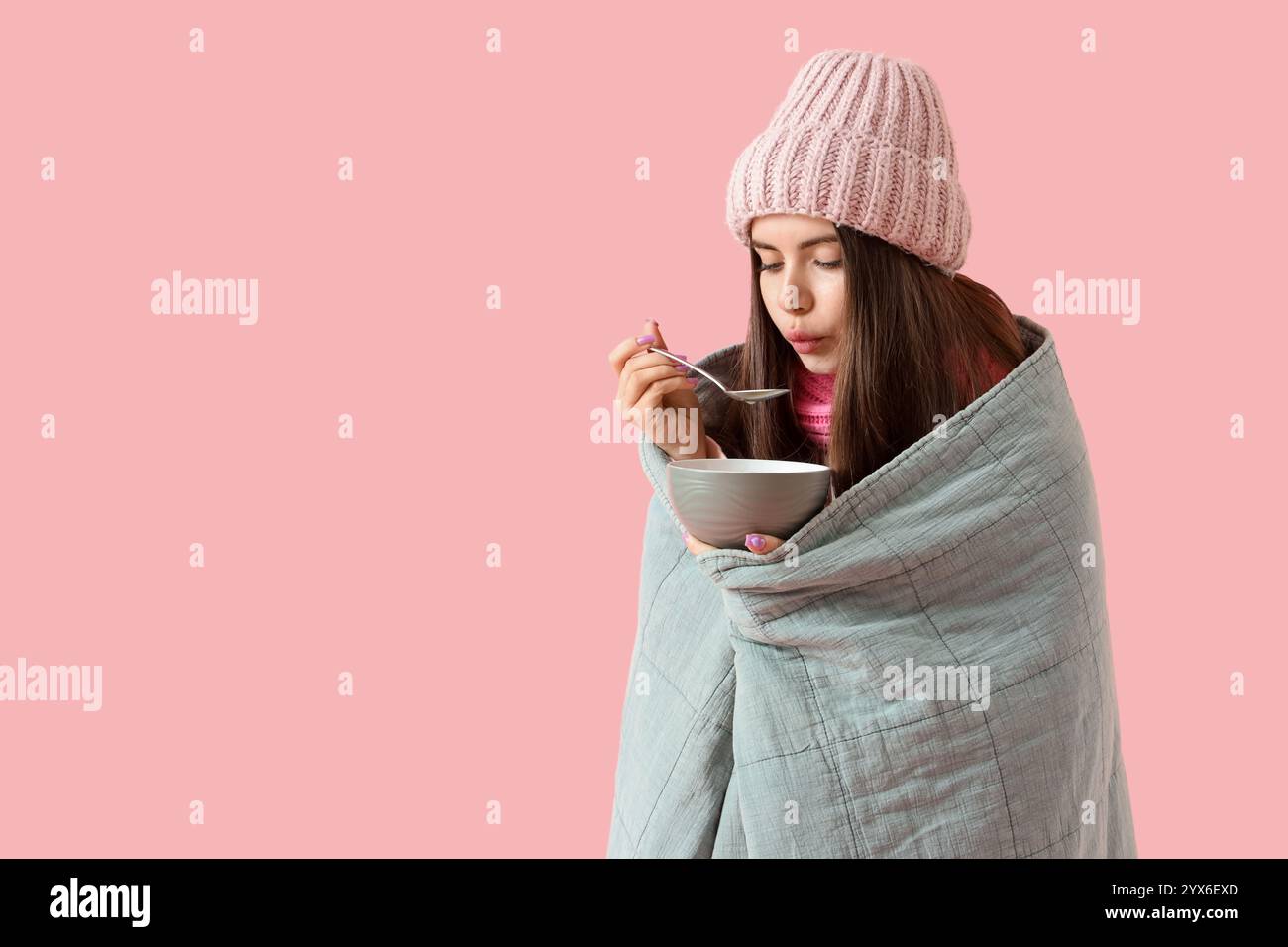Ill young woman eating chicken soup on pink background Stock Photo - Alamy