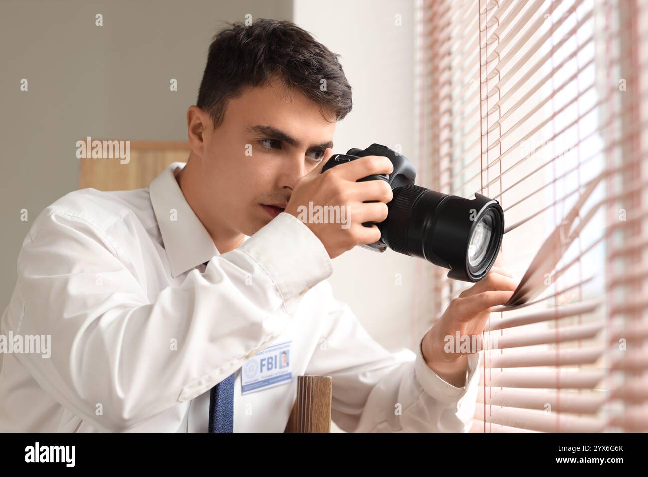 Male FBI agent taking pictures near window in office Stock Photo - Alamy