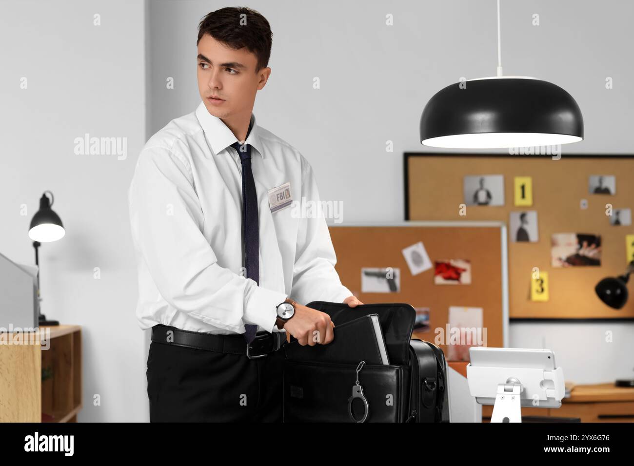 Male FBI agent taking notebook from briefcase in office Stock Photo - Alamy